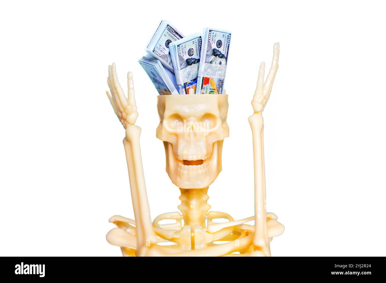 Anatomical skeleton model with arms raised, filled with money on white ...