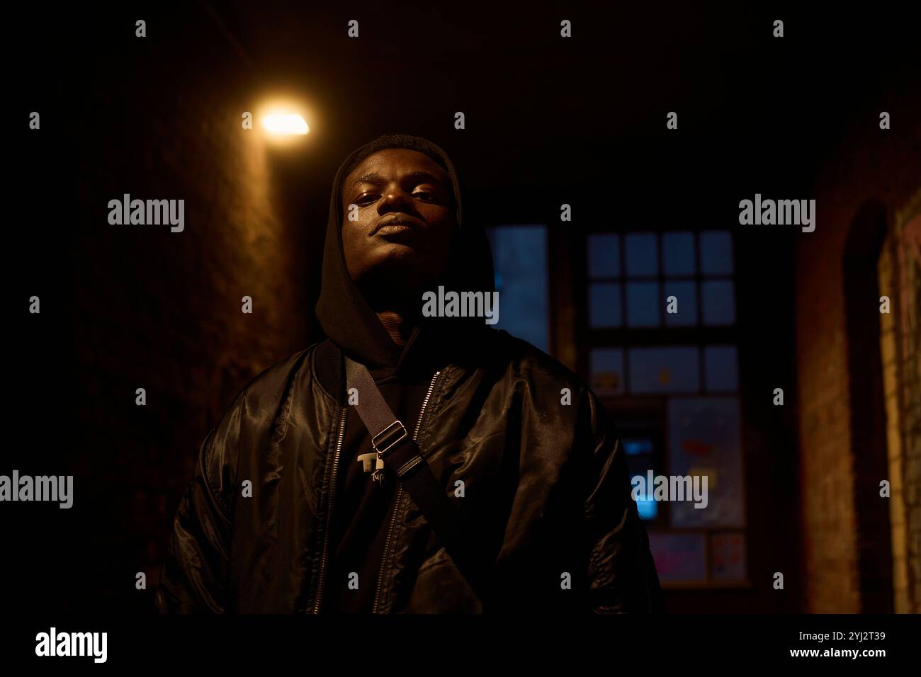 Silhouetted young man standing dimly lit urban alleyway night hi-res ...
