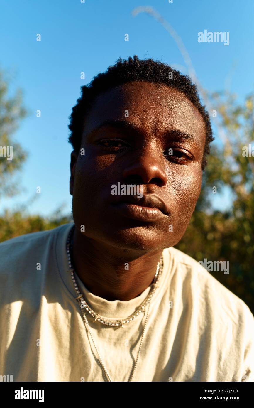 Close-up portrait of a young man with serious expression standing ...