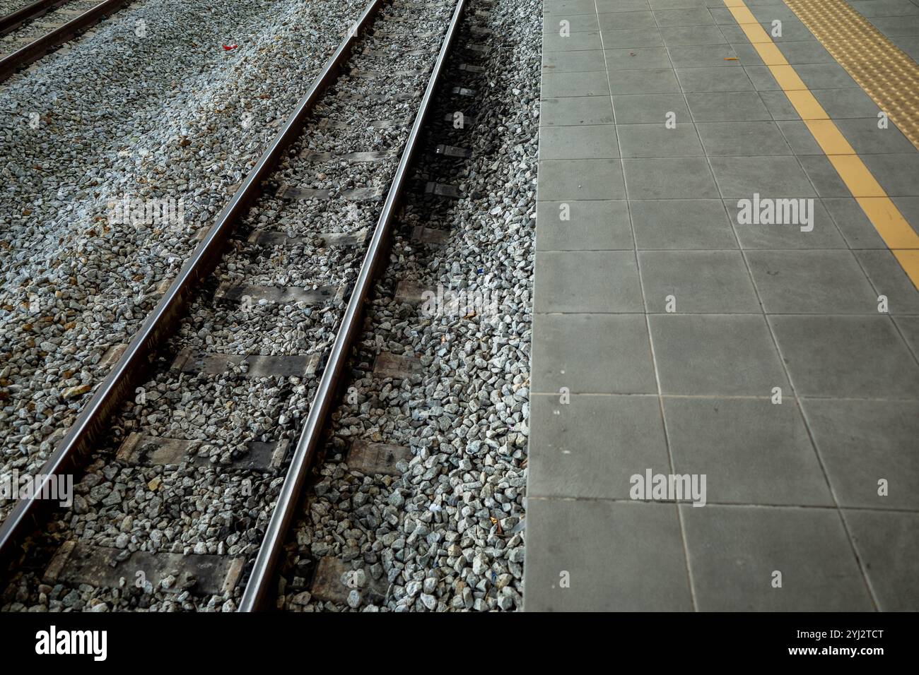 View of a train tracks on ballast gravel and railway sleeper wood. A ...