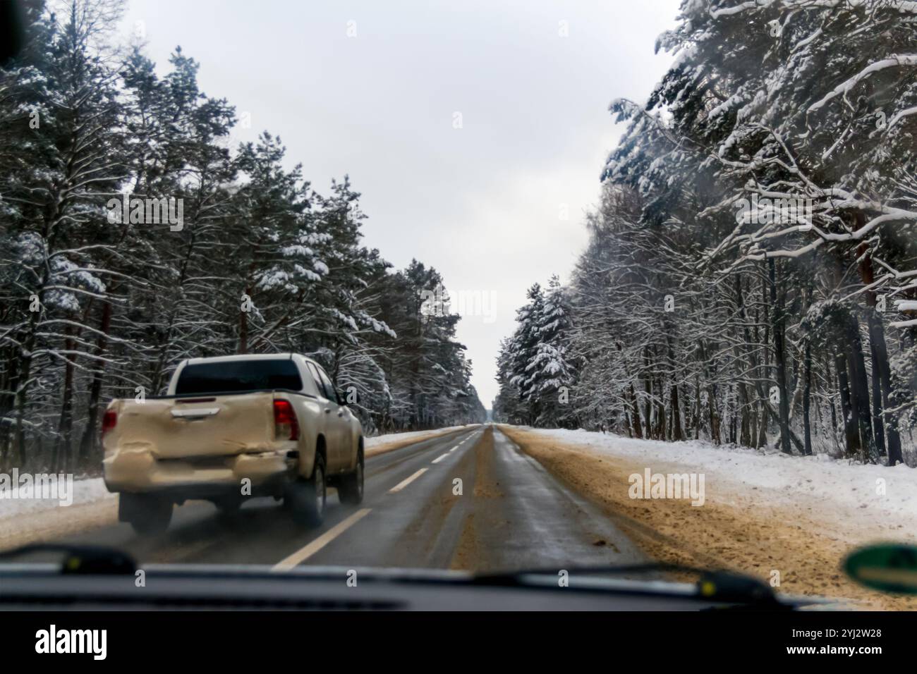 Winter road scene with a pickup truck attempting a dangerous overtaking ...