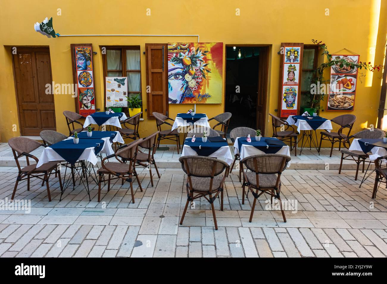 Outdoor cafe with wooden tables, stools on a city street. Historic ...