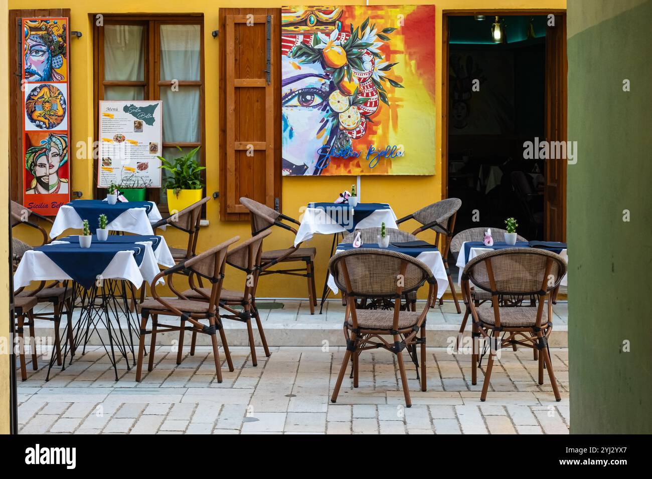 Outdoor cafe with wooden tables, stools on a city street. Historic ...