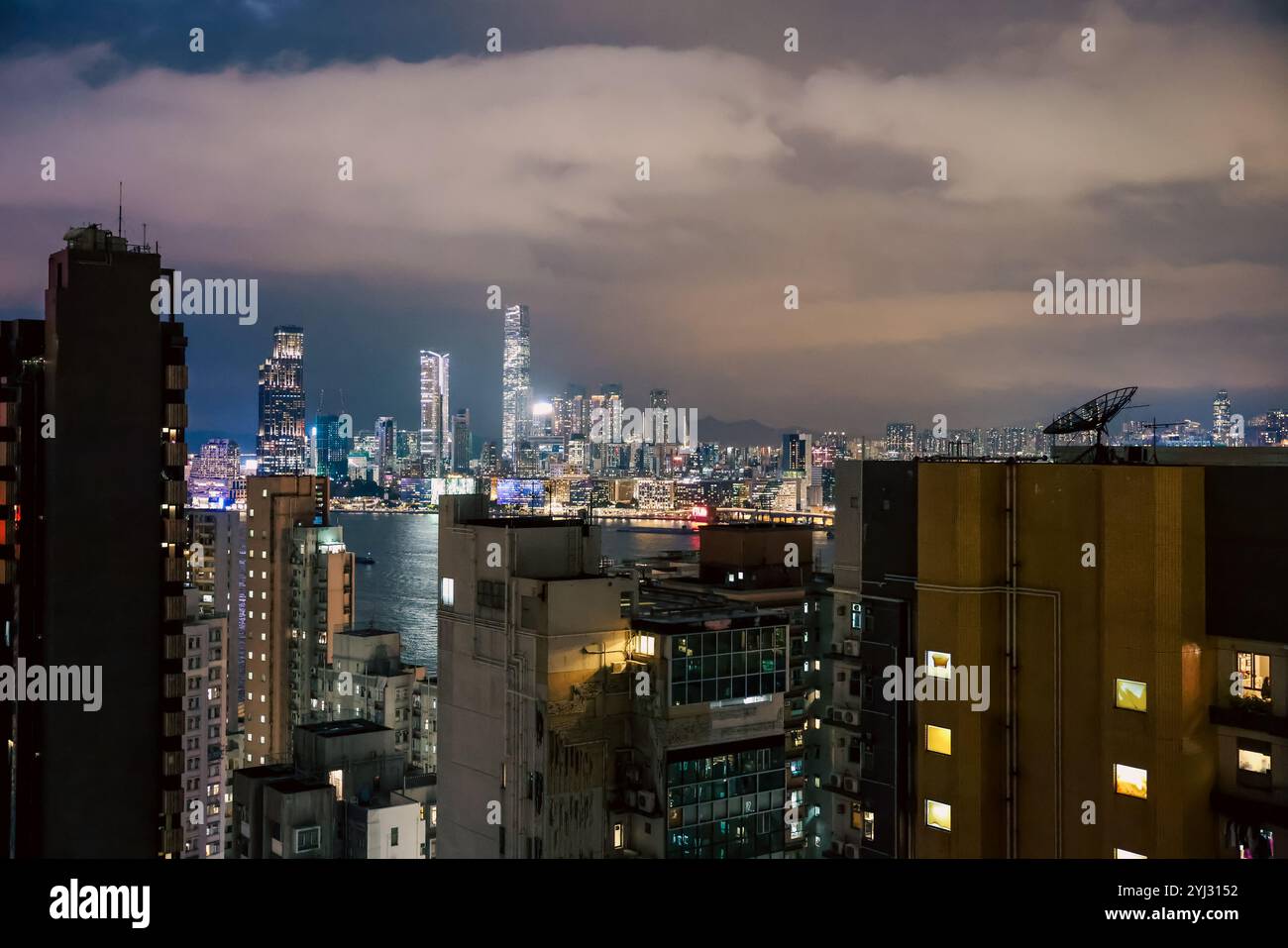 Brightly lit high-rise buildings illuminate the Hong Kong skyline at night, showcasing the ...