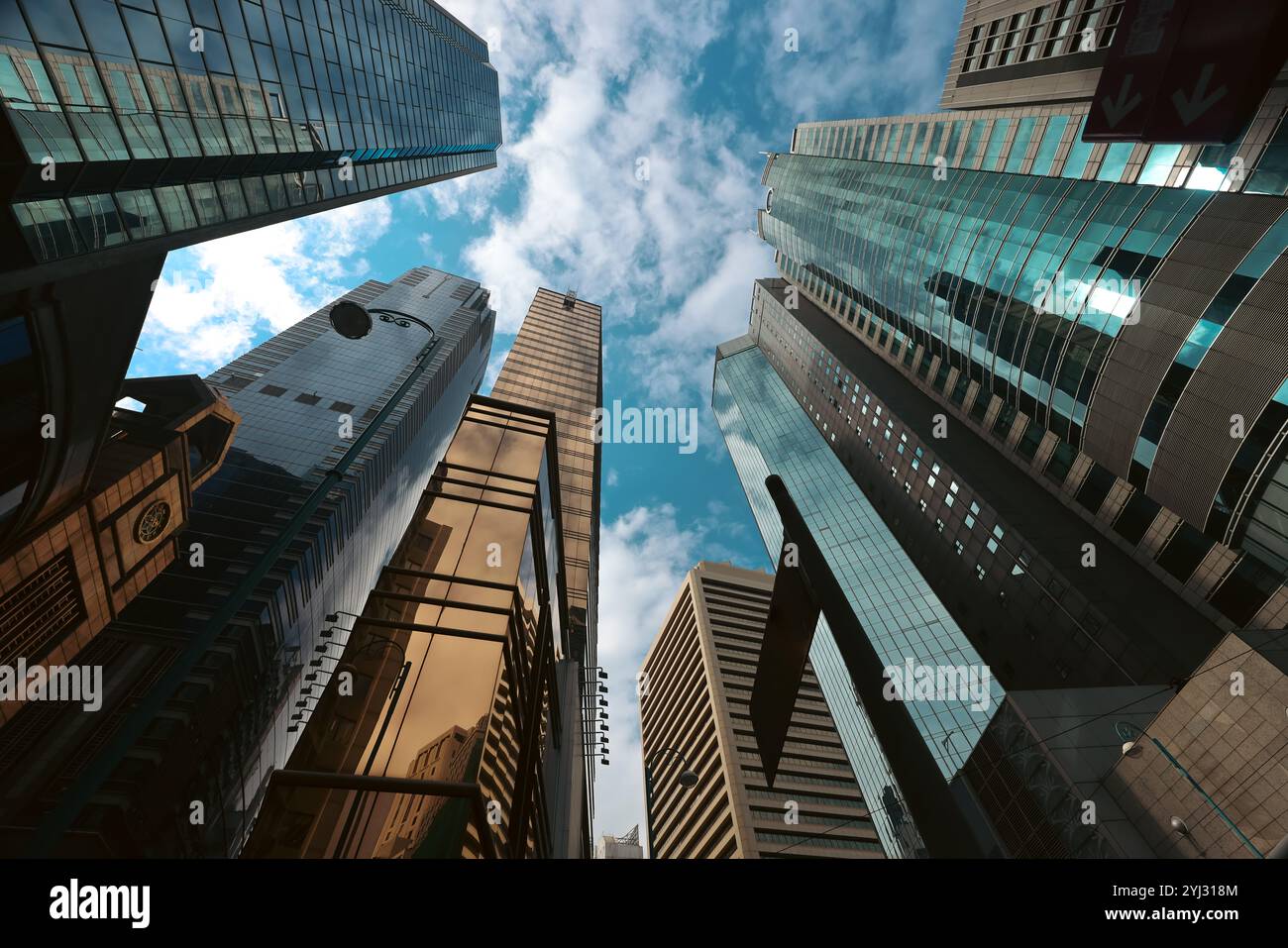Tall high-rise buildings tower in central Hong Kong under a bright blue ...