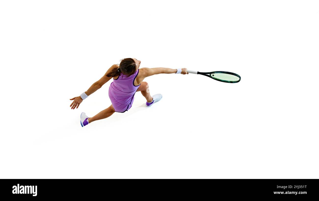 In motion, female tennis player lunges towards ball, body extended to ...