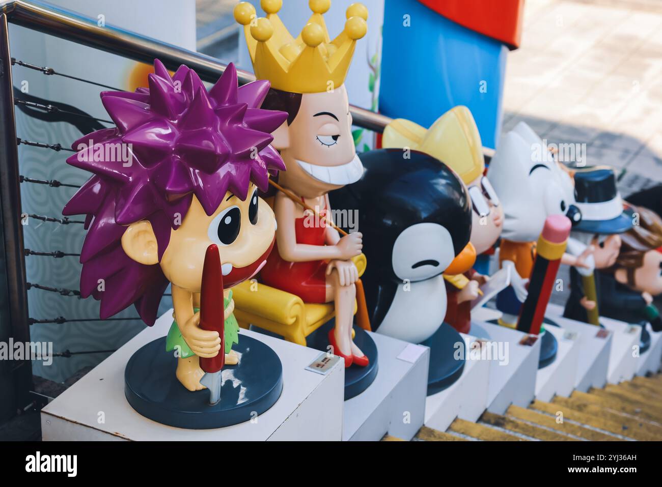 Brightly colored cartoon figures line the steps in an urban area ...