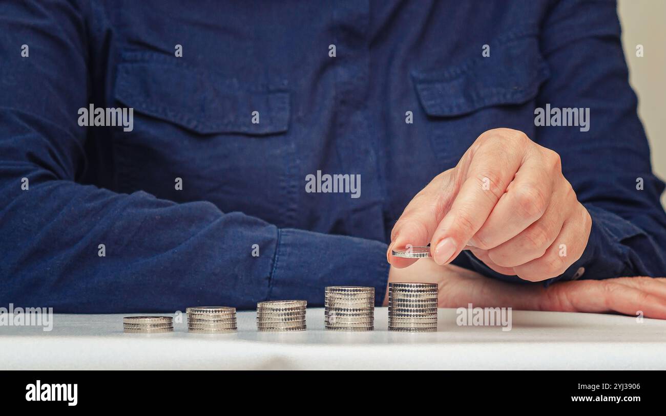 Woman's hand puts coin on pile. Rising growth step, money saving ...