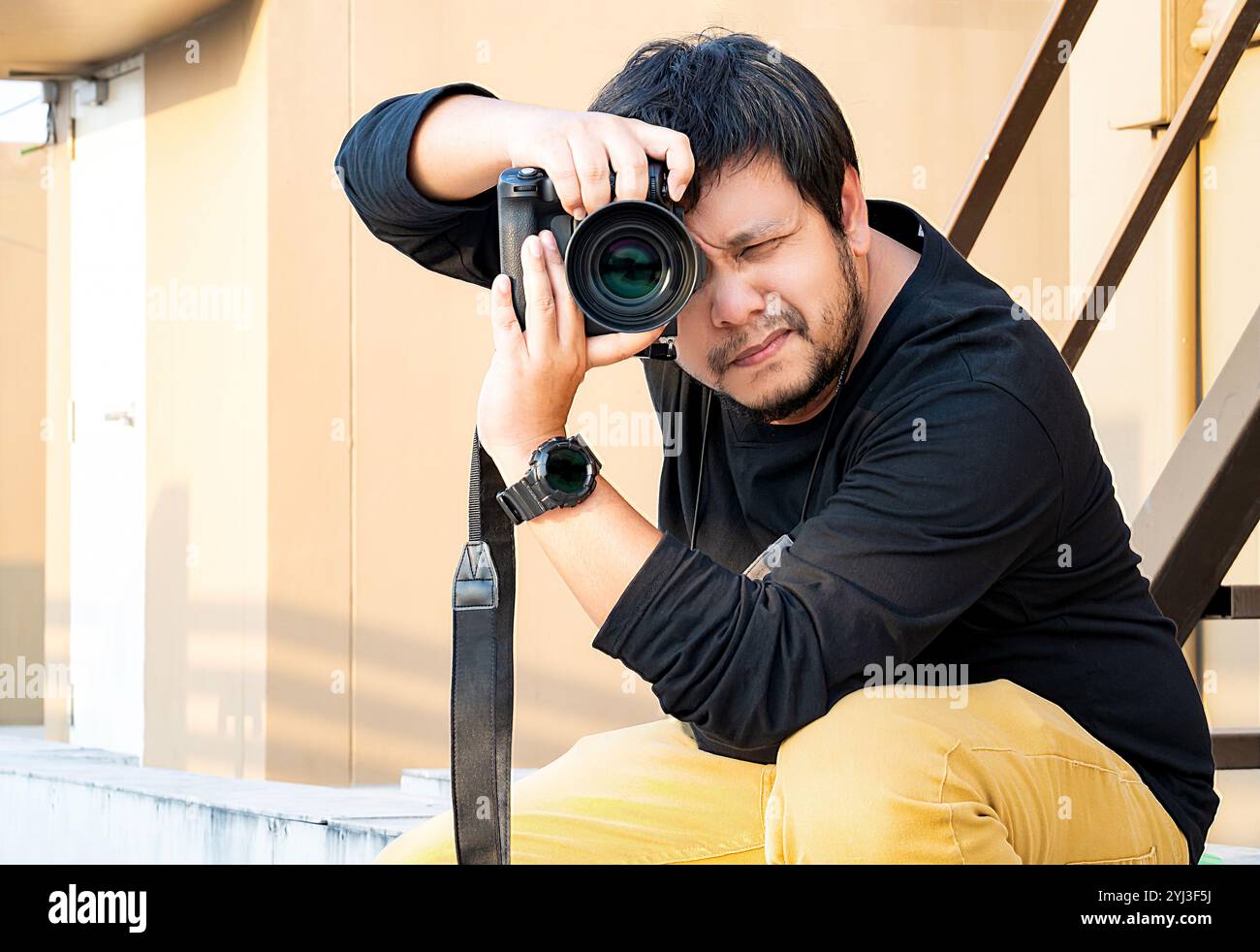 Asian Professional Camera man looks in to camera viewfinder and focus ...
