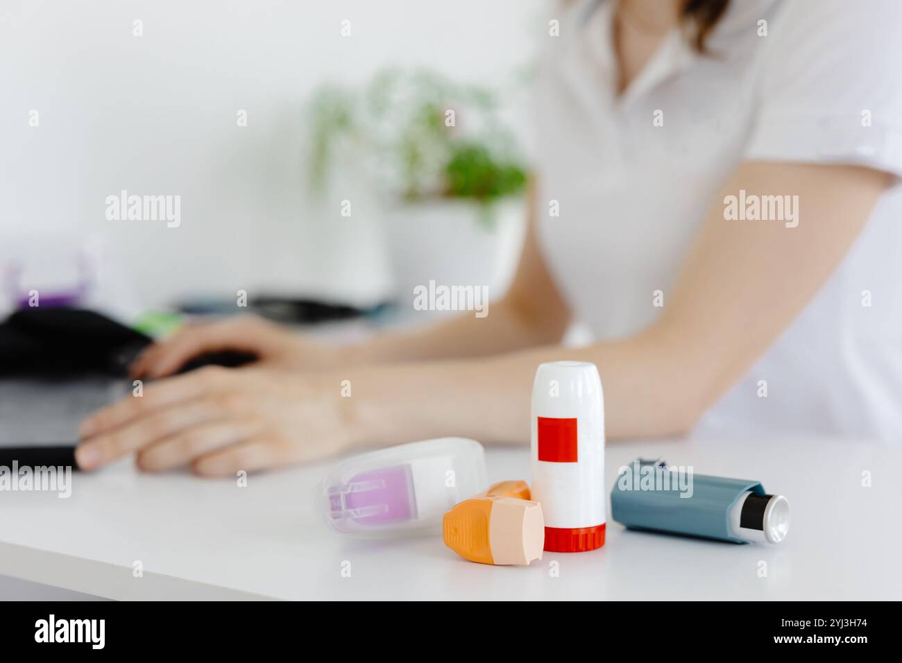 Doctor writes at laptop medical prescription for asthma inhaler to ...