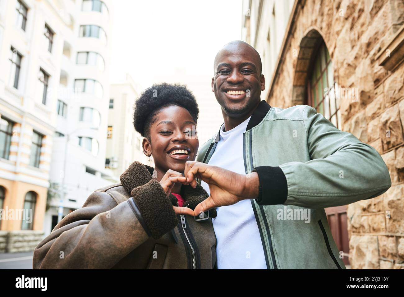 Smiling Couple Creating Heart Shape With Hands in Urban Setting Stock ...