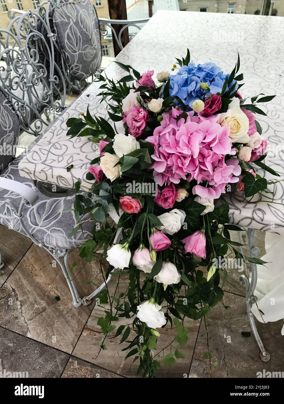 A stunning cascading floral arrangement with pink and blue hydrangeas ...