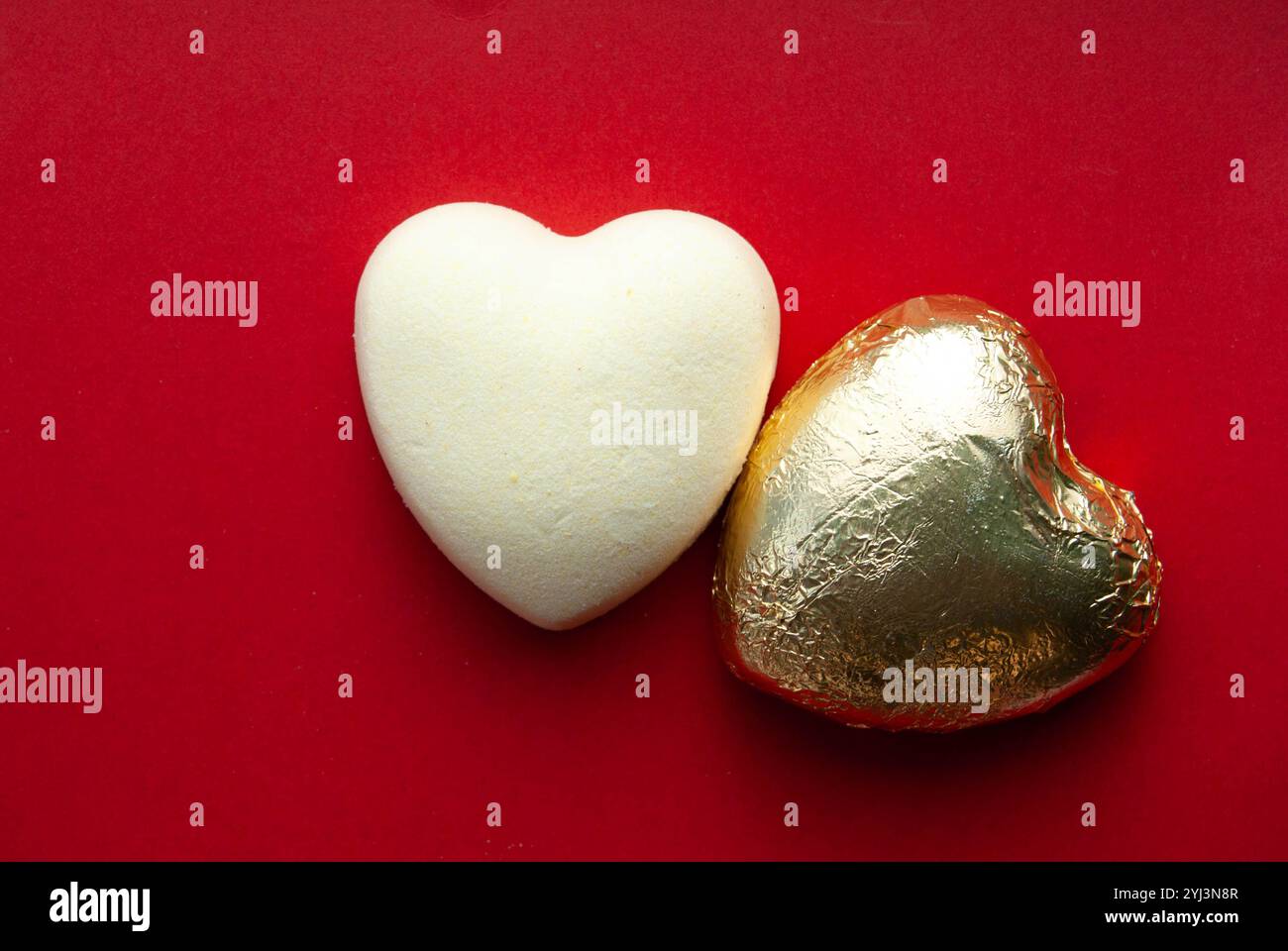 A simple yet elegant white and gold chocolate heart against a red ...