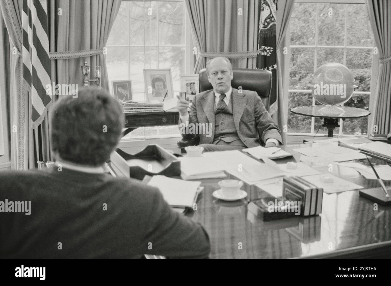 President Gerald Ford sitting at his desk talking with speechwriter Bob ...