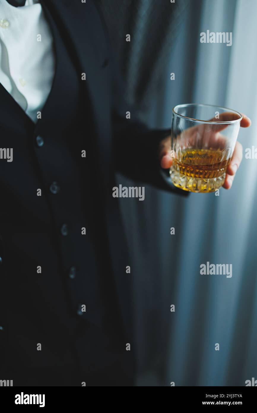 A man's hand in a classic suit with a glass of whiskey. Drinks for men ...