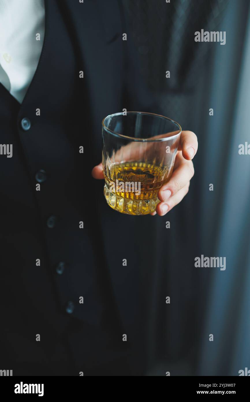 A man's hand in a classic suit with a glass of whiskey. Drinks for men ...