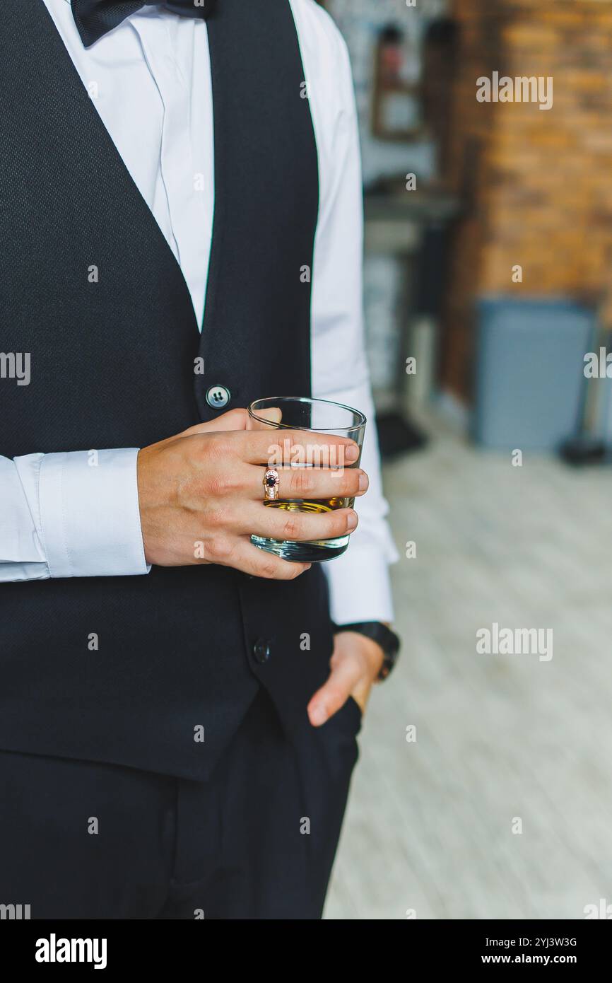 A man's hand in a classic suit with a glass of whiskey. Drinks for men ...