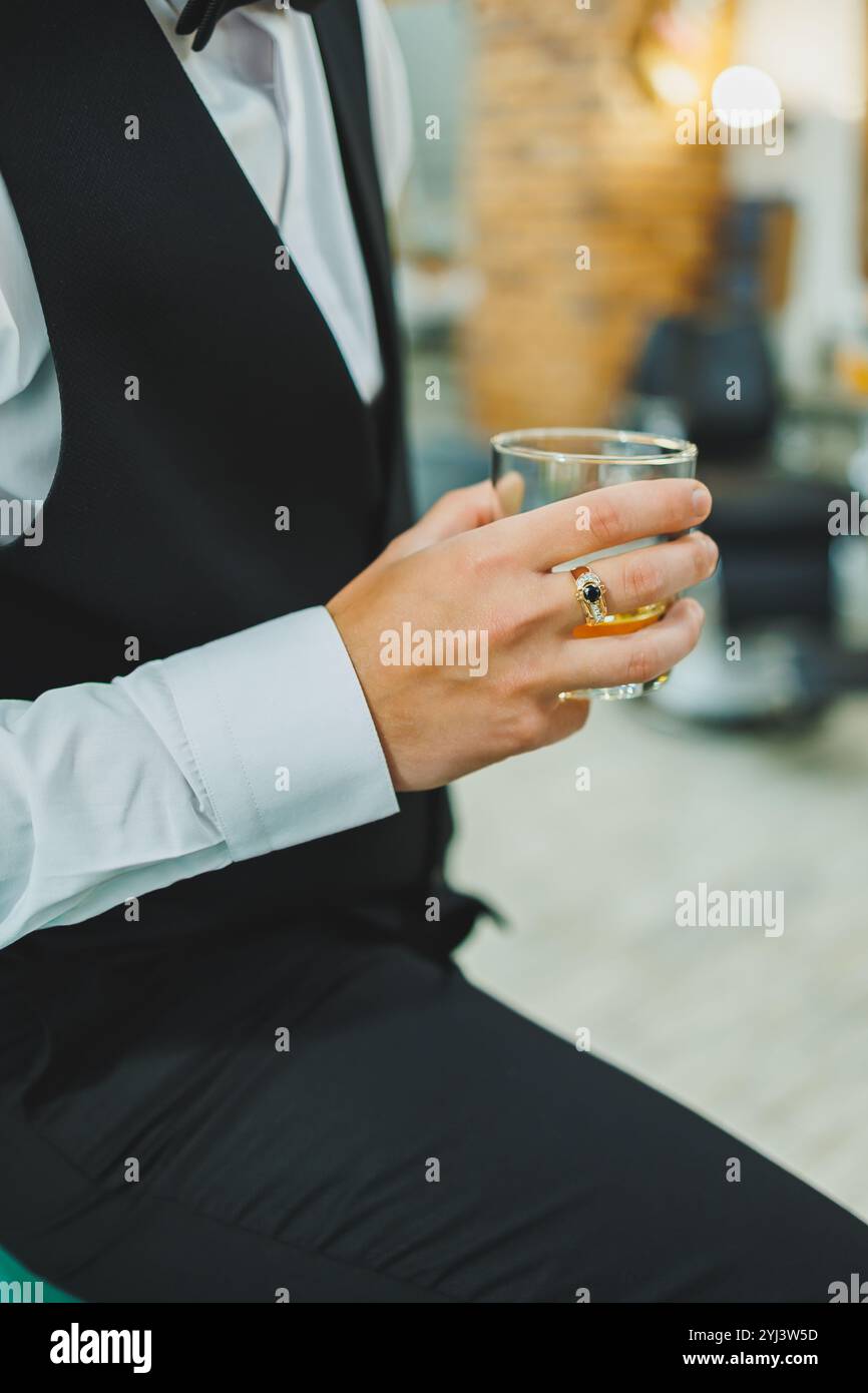 A man's hand in a classic suit with a glass of whiskey. Drinks for men ...