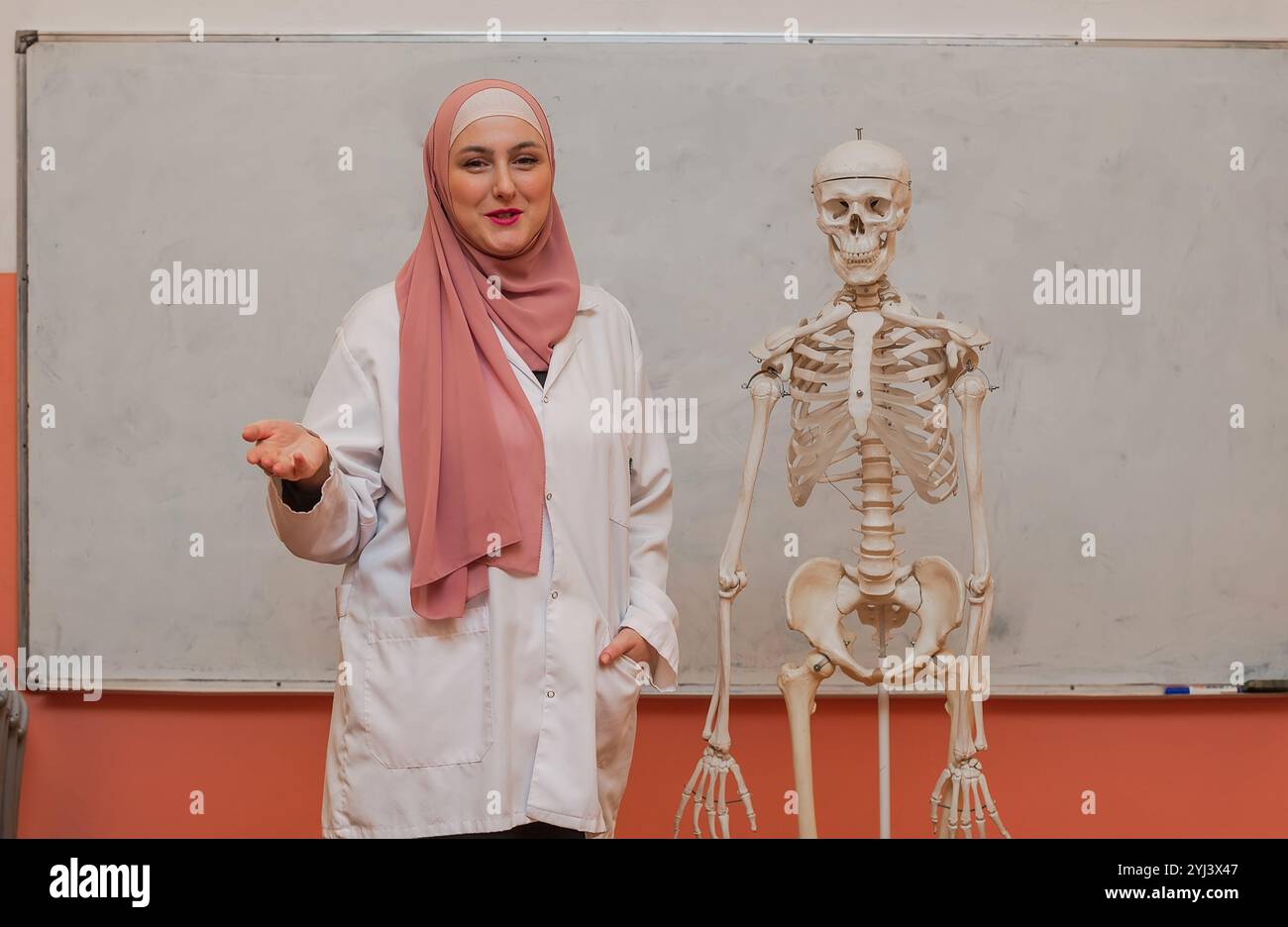 A Muslim female teacher teaches students using the human body skeleton ...