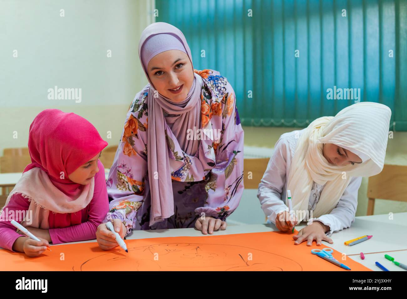 Group of Muslim school children with their female teacher working ...