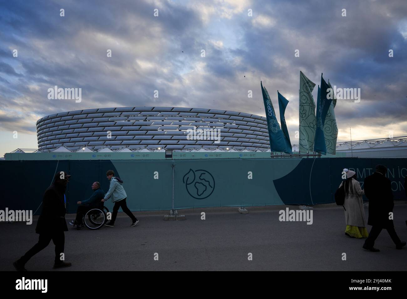 People walk outside the Baku Olympic Stadium, the venue for the COP29 U ...