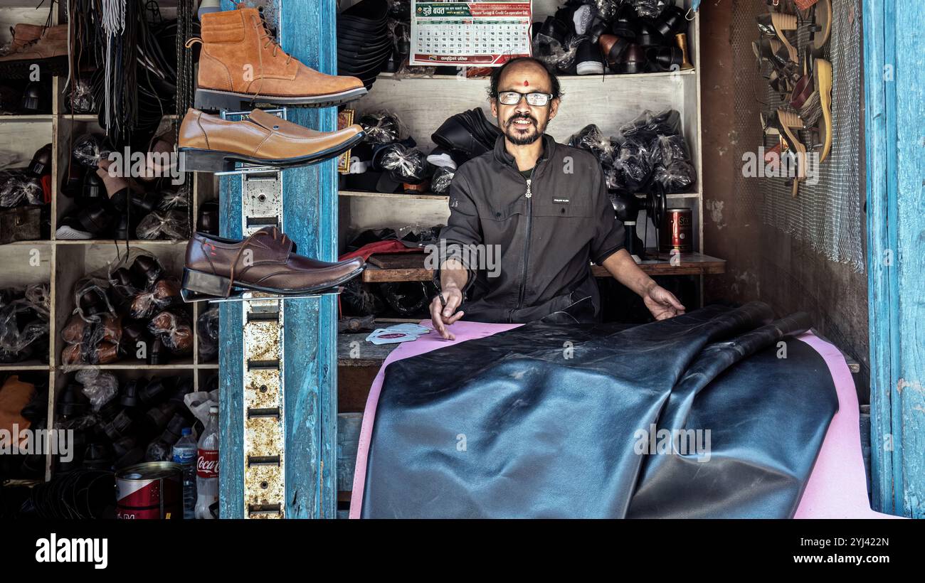 A Nepalese cobbler at his shop in Kathmandu, surrounded by handmade ...