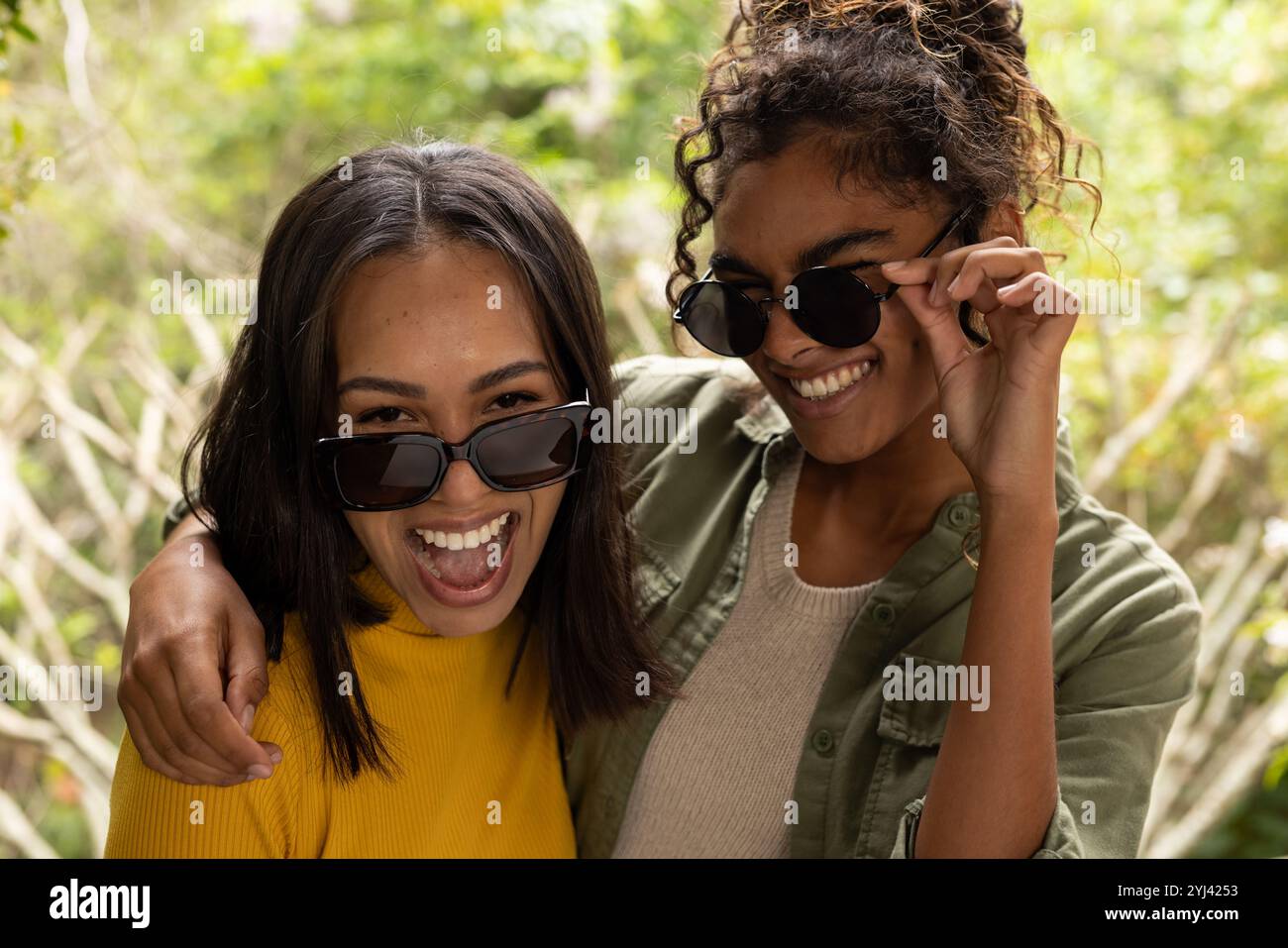 Two multiracial female friends on deck laughing and enjoying sunny day ...
