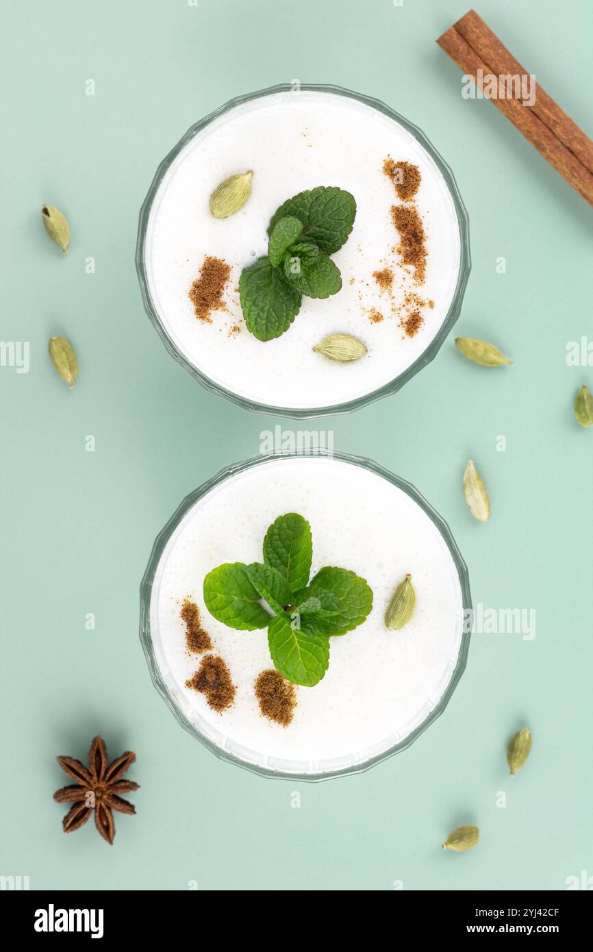 Traditional Indian cold drink lassi in a glass with spices and mint on ...