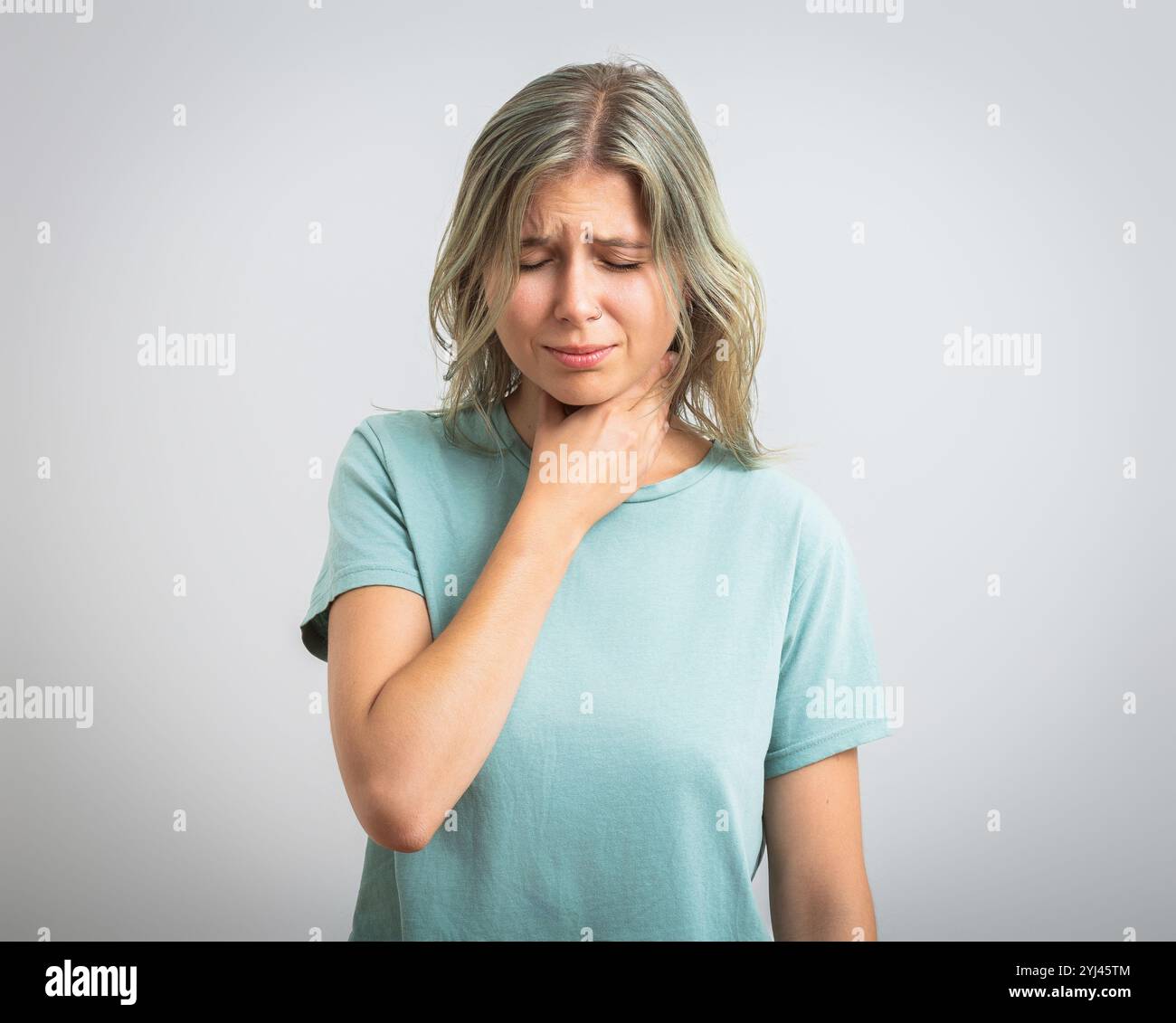Sick woman having sore throat, feeling sick, holding hand on her neck ...