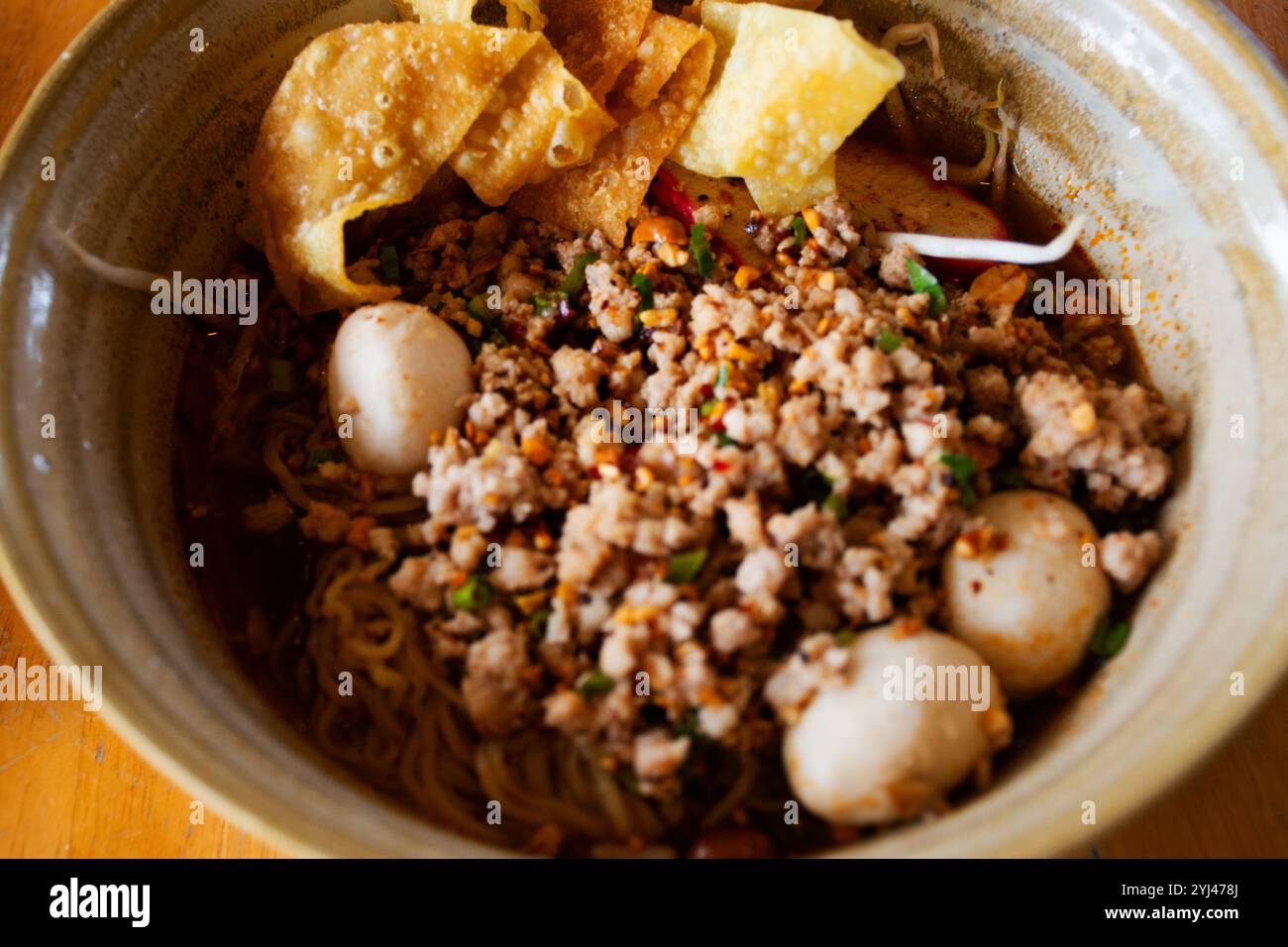 Traditional local thai street food Tom Yum Moo Sab noodle soup or noodles in hot and sour broth ...