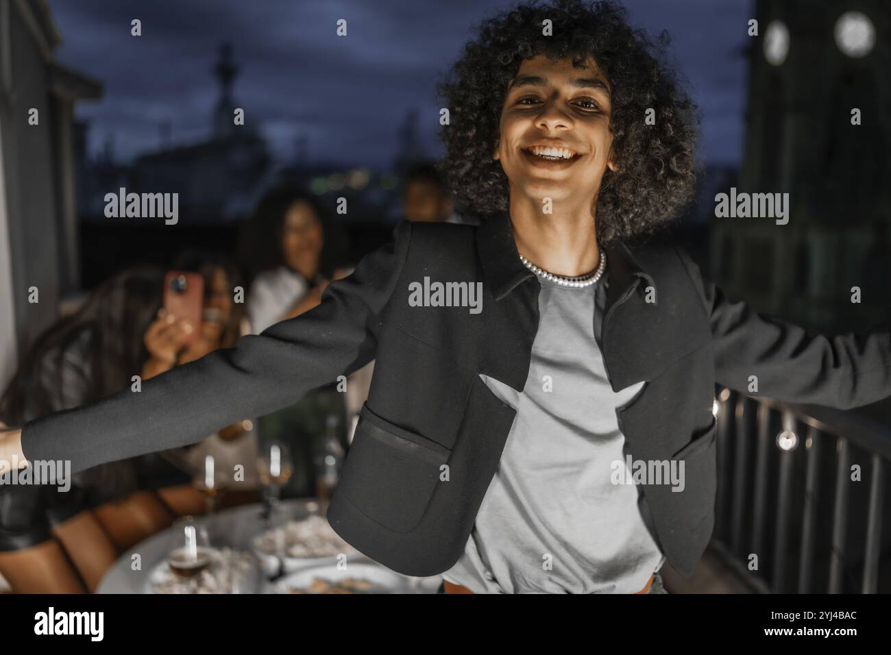 Man dancing happily during night party in a rooftop with multiracial ...
