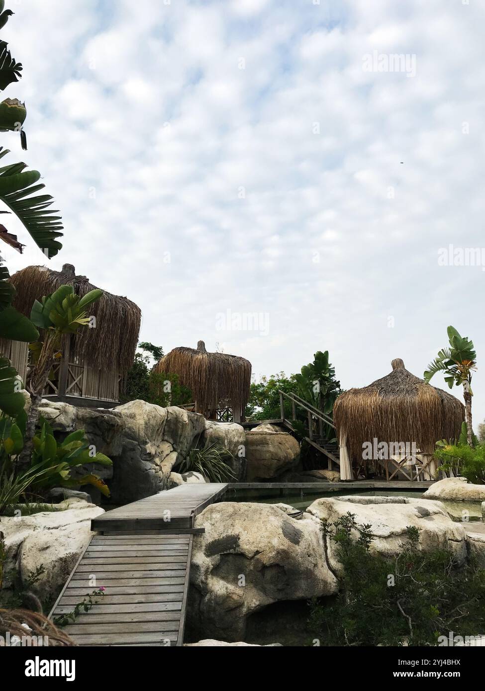 A peaceful tropical resort featuring charming thatched huts, surrounded ...
