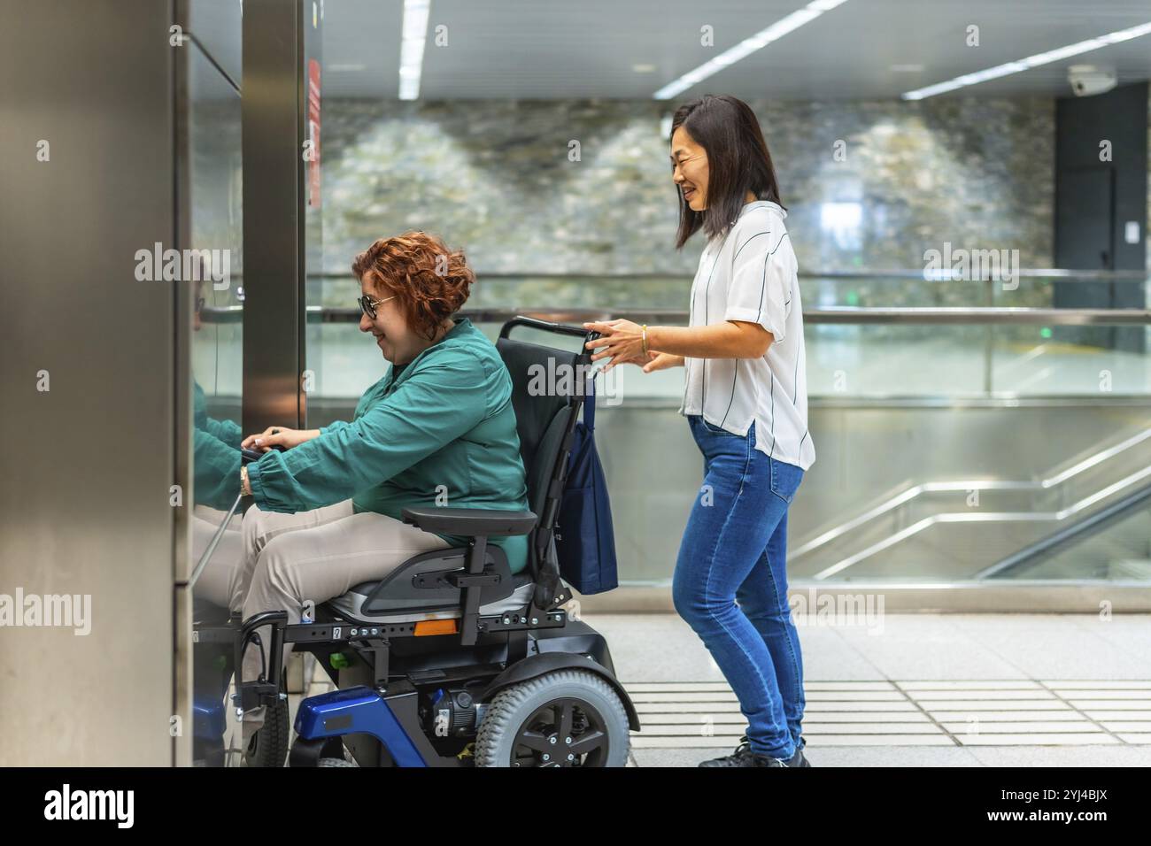Side view of a chinese female caregiver pushing wheelchair of a ...