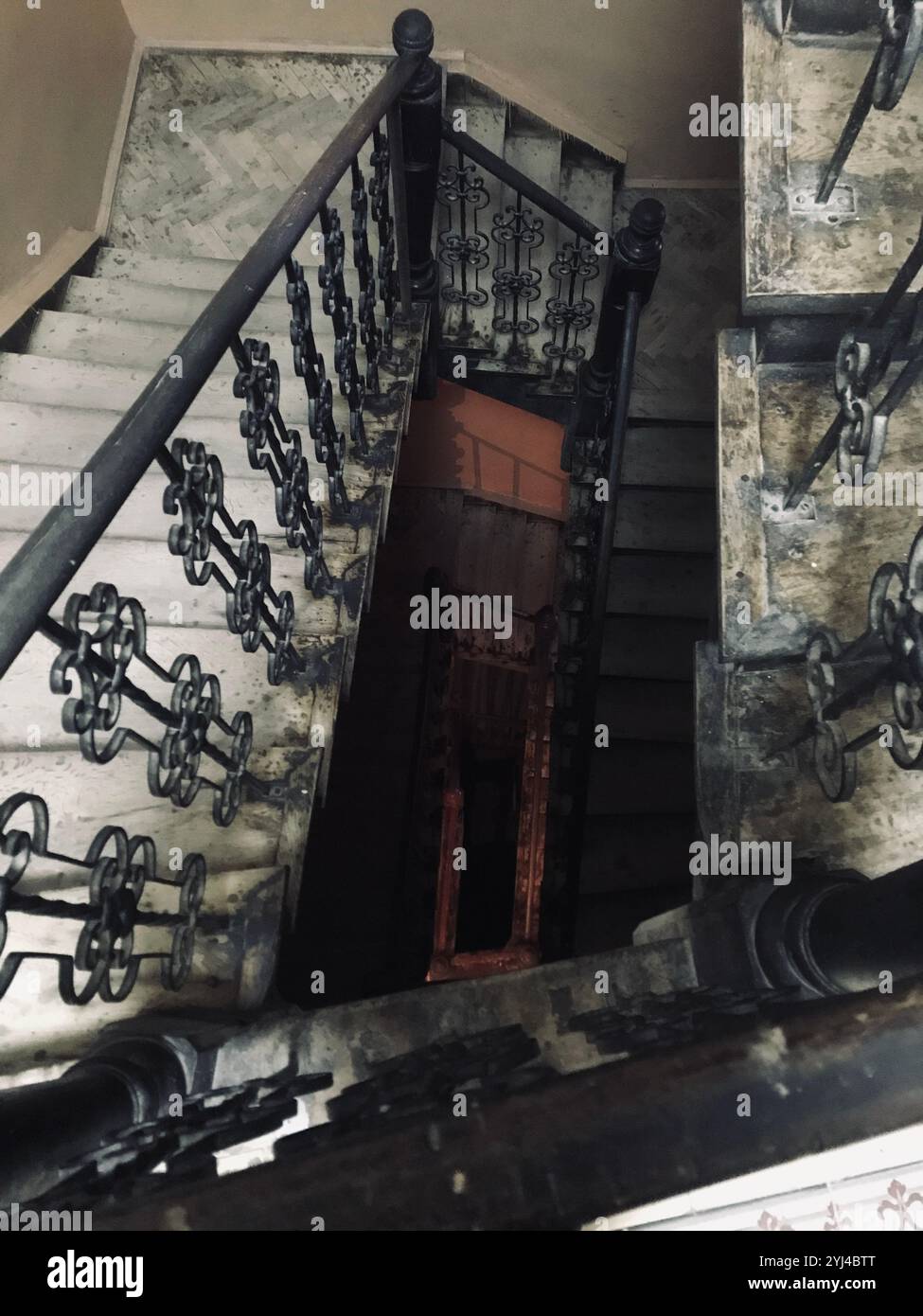 An old spiral staircase with intricate iron railing, captured in low ...