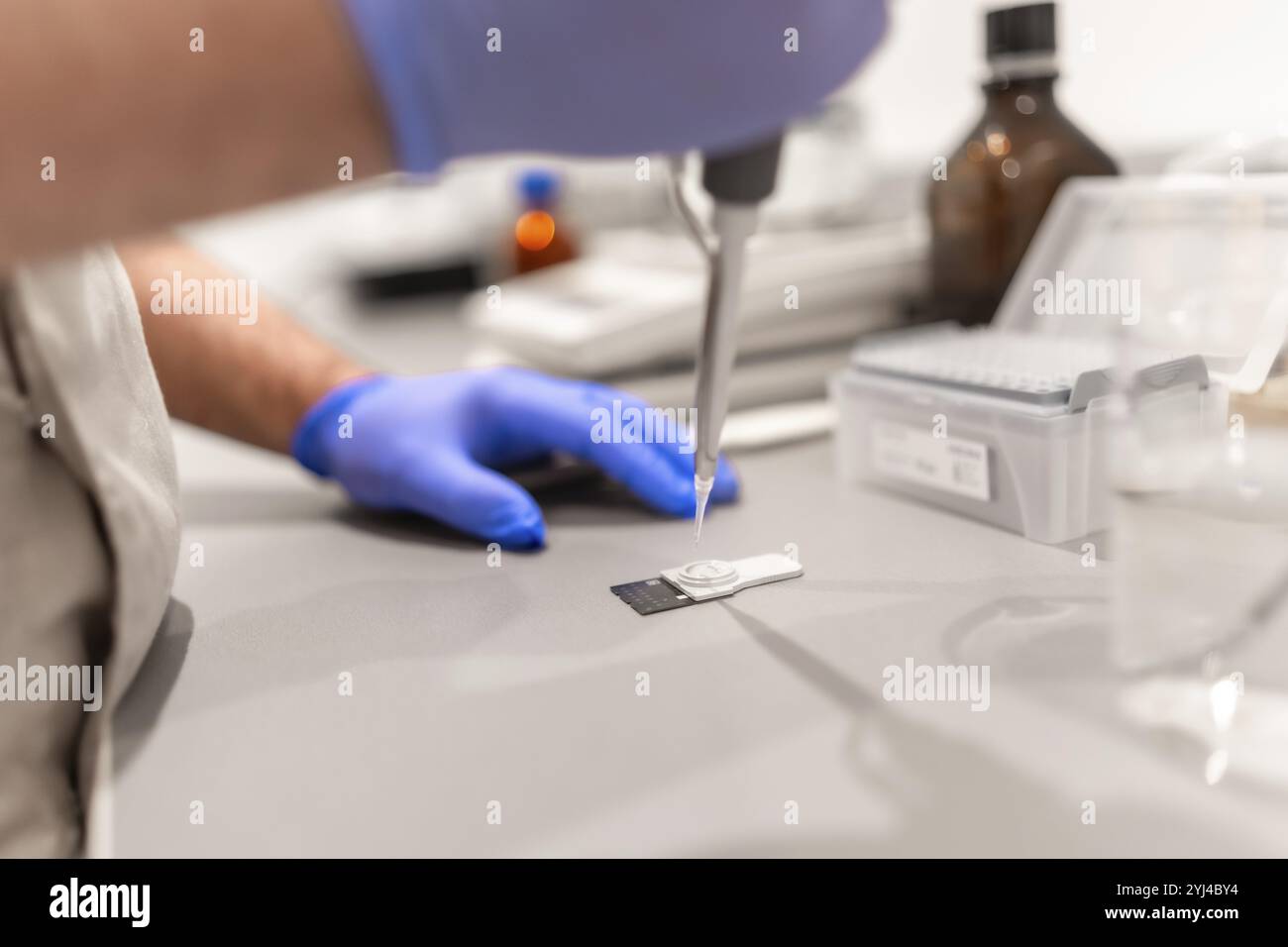 Side view close-up of an unrecognizable doctor using pipette to test ...