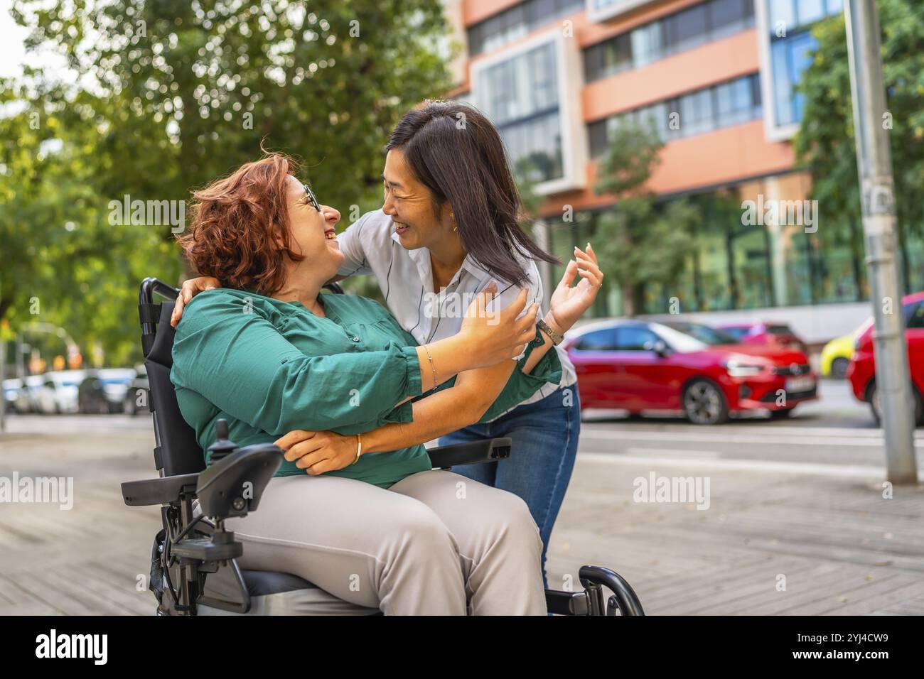 Woman with disability in wheelchair and multi-ethnic friend reunited ...