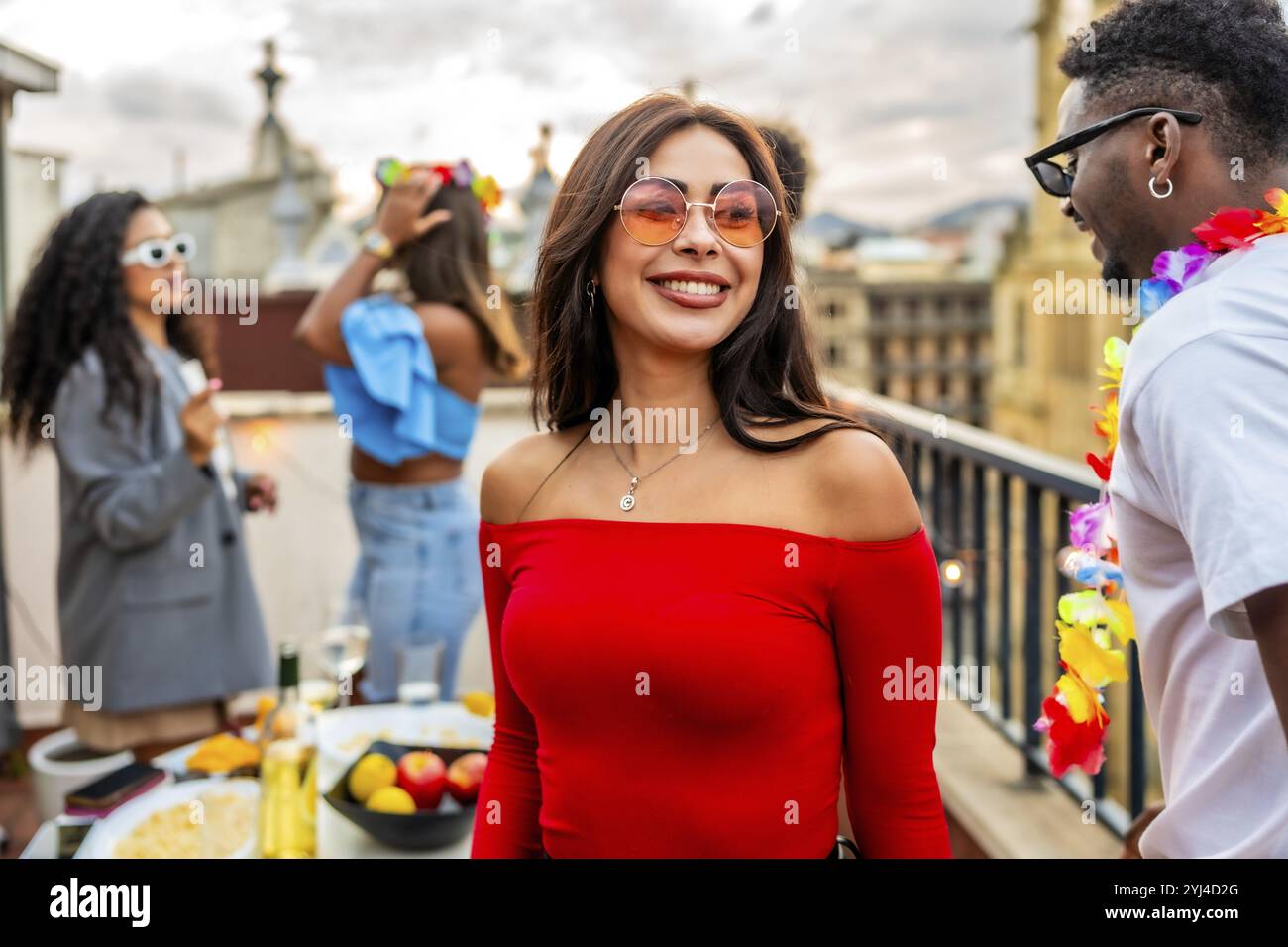 Chic beauty woman smiling while friends partying outdoors in a rooftop ...