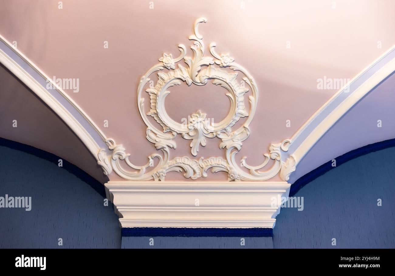 White bas-relief decoration details over blue pink ceiling and wall ...