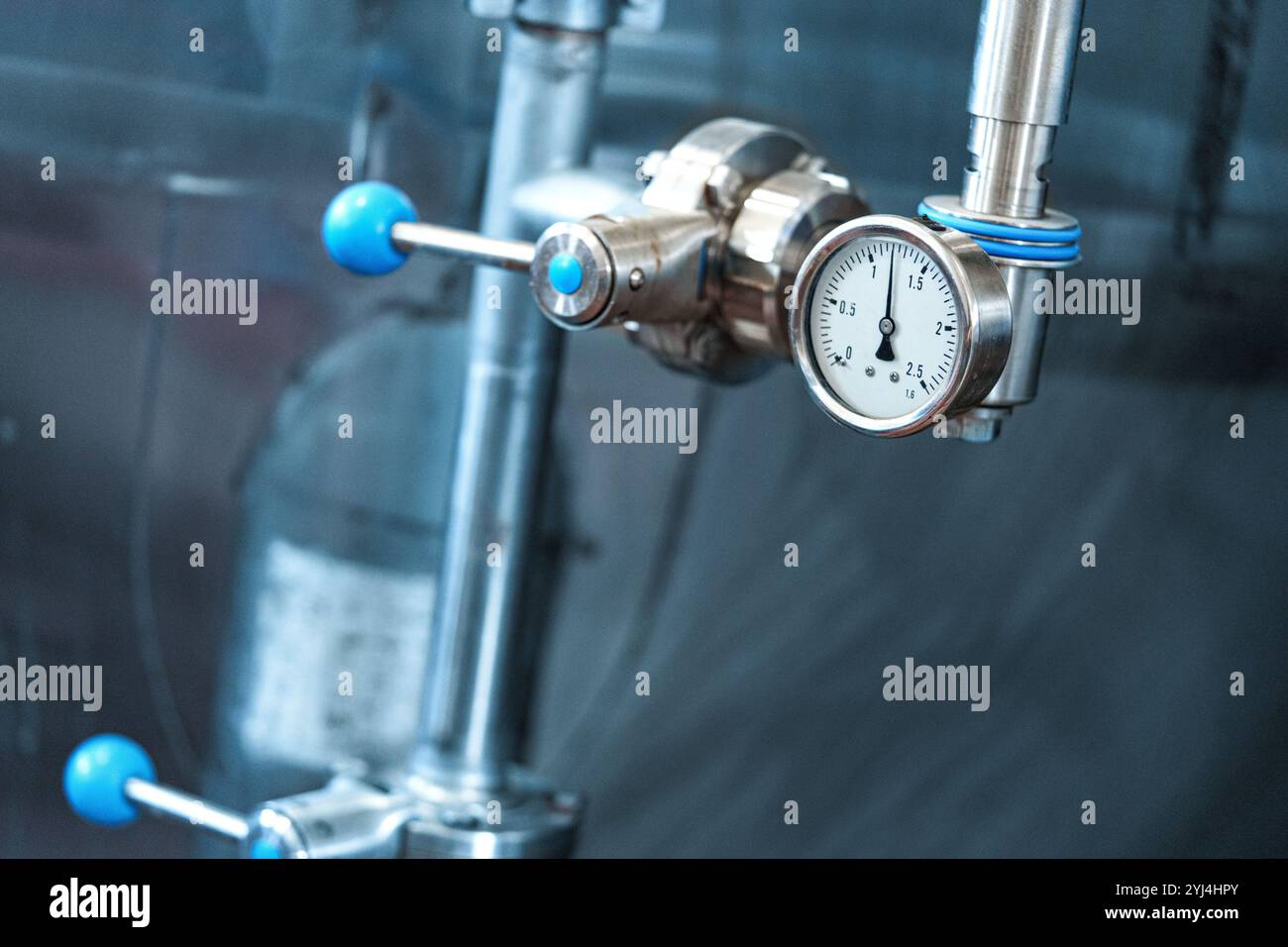A close-up of a pressure gauge mounted on a pipe in an industrial ...