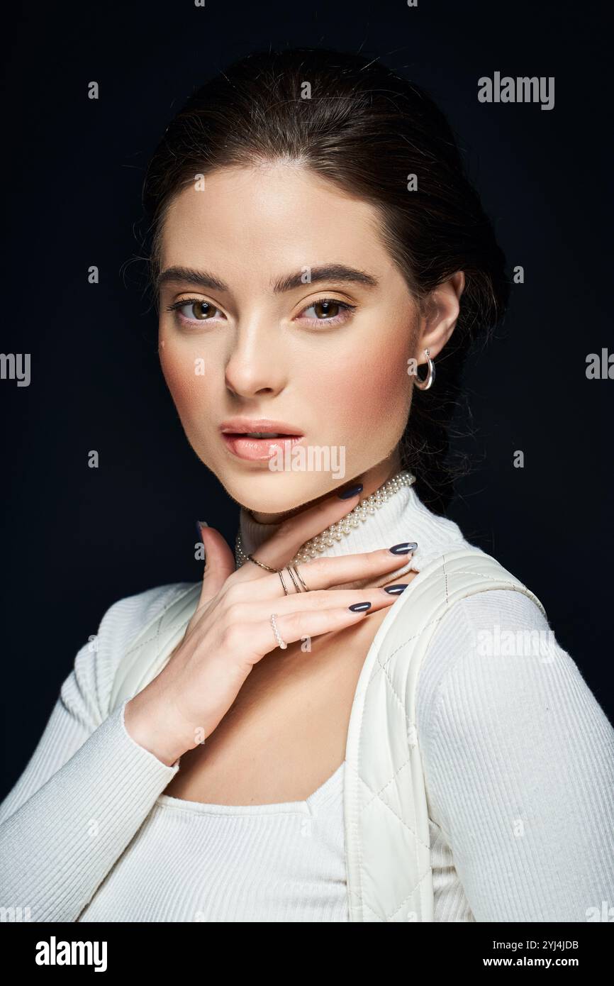 A stylish woman gracefully poses with an expressive gaze and chic ...