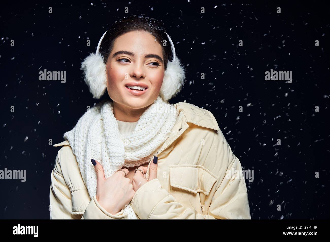 Amidst falling snowflakes, a woman embraces the winter chill wearing ...