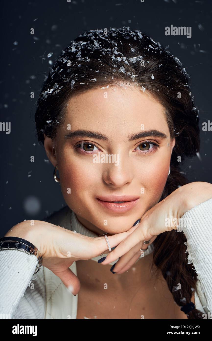 A stunning woman enjoys the moment as delicate snowflakes gently ...