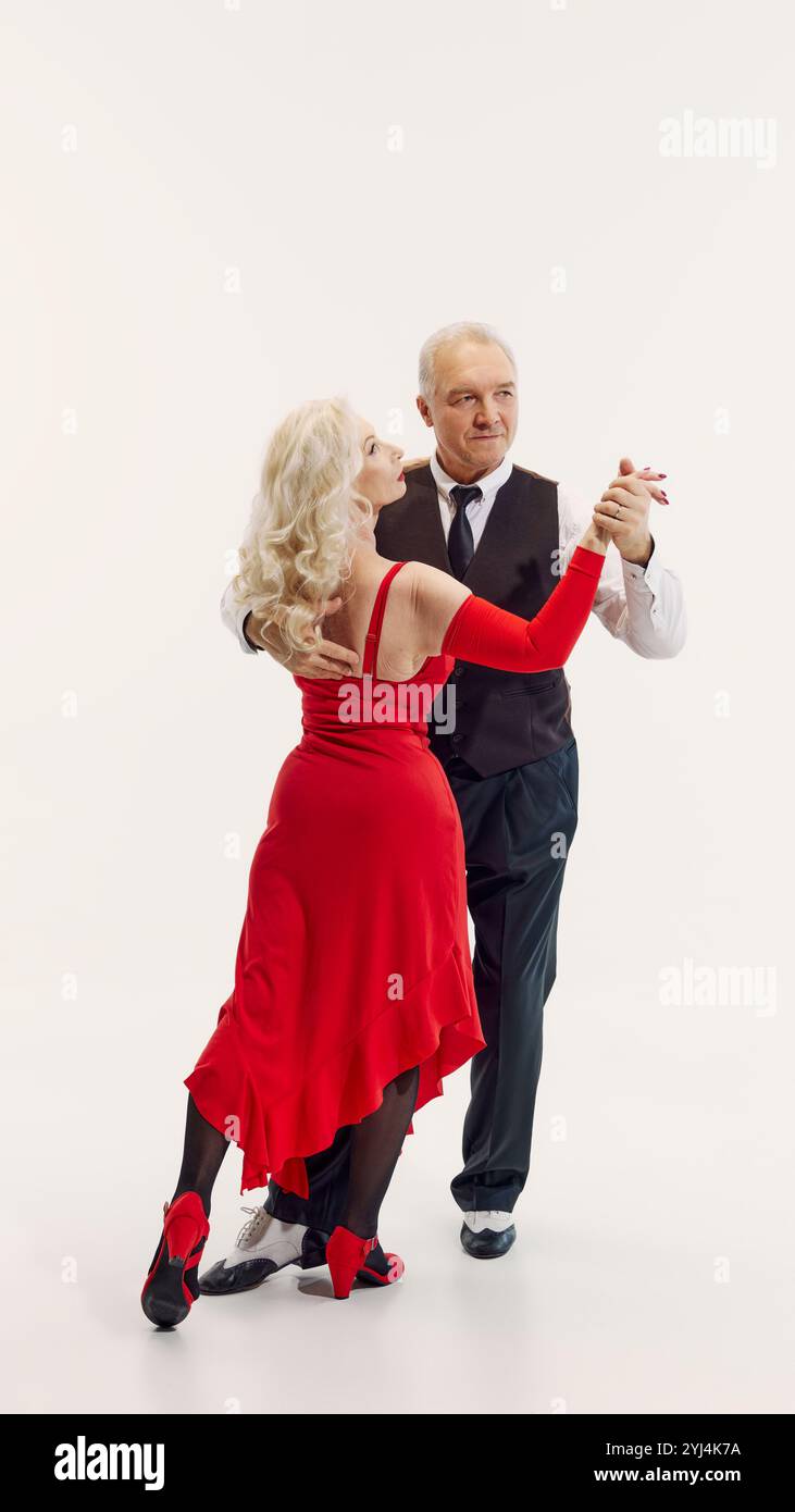 Elegant senior blonde woman in red dress and handsome senior man in ...