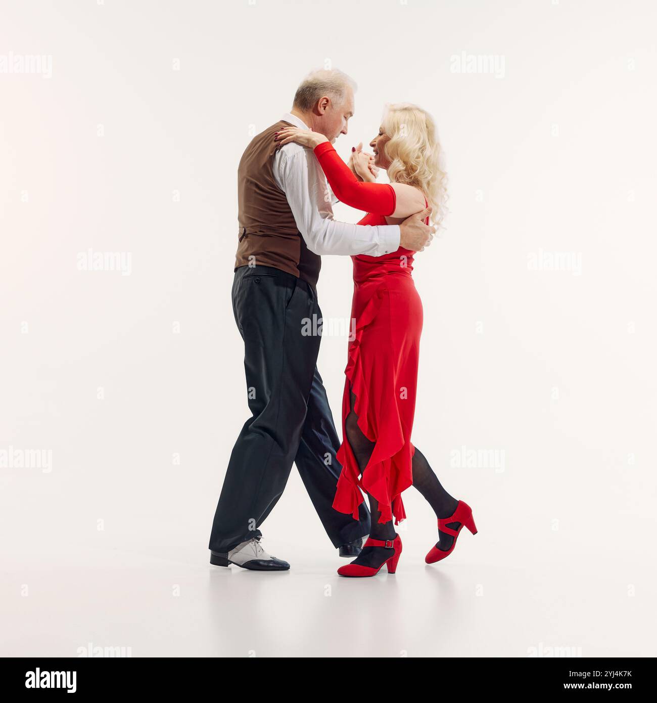 Elderly woman and senior man, elegantly dressed in red dress and black ...