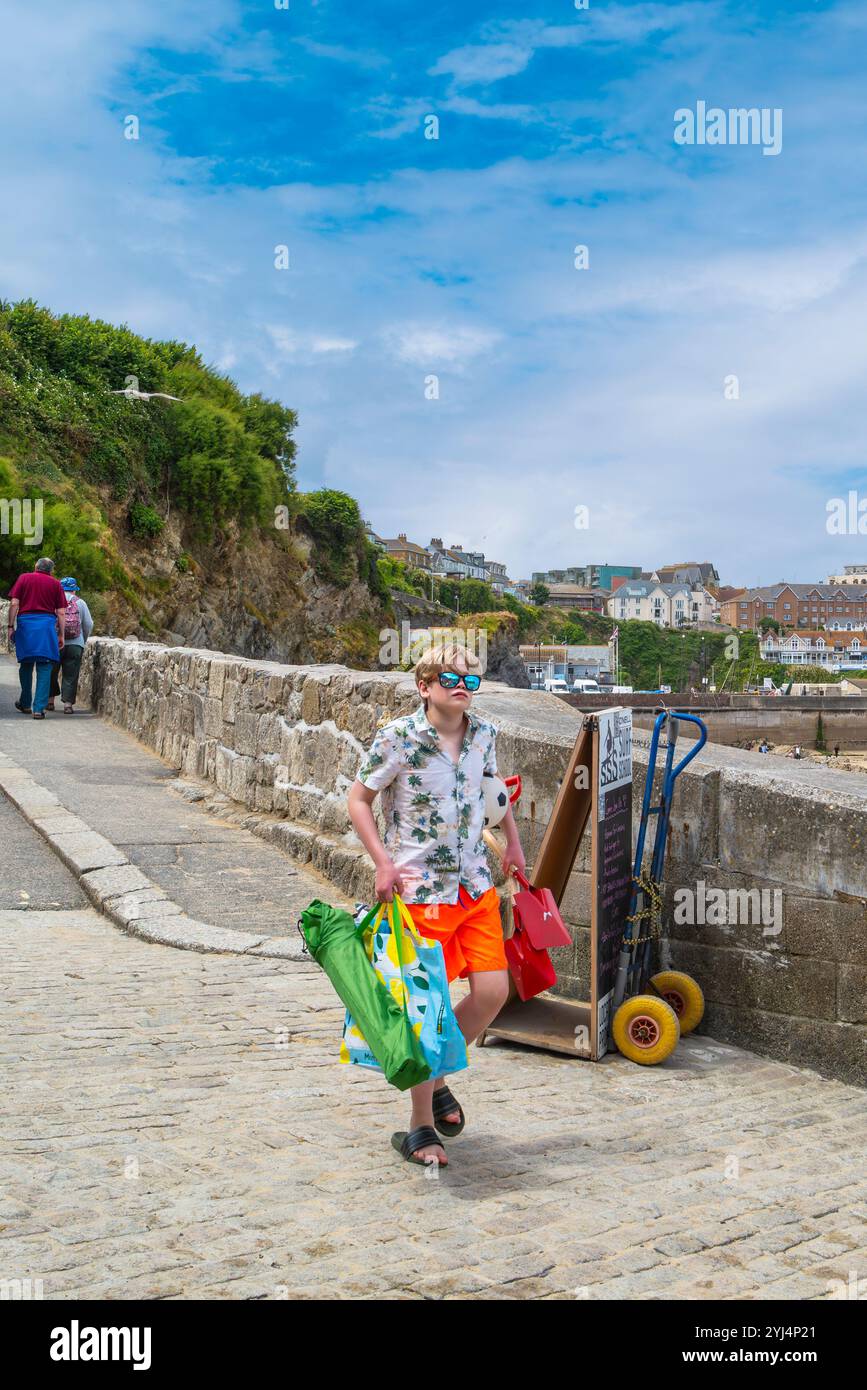 A young boy arriving at Towan Beach in Newquay in Cornwall in the UK ...