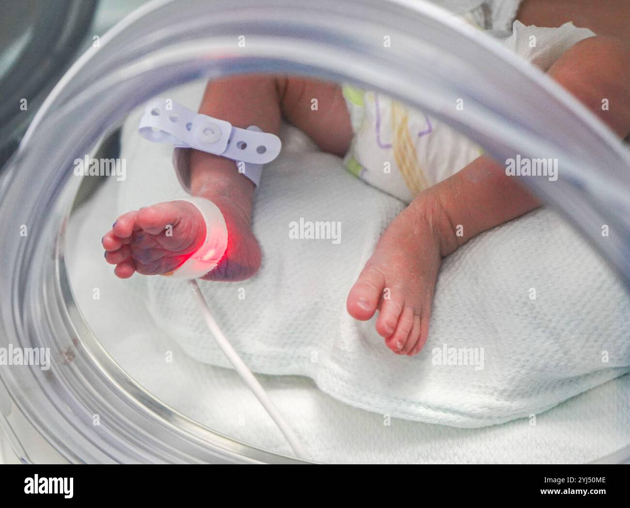 Closeup view of a Premature baby in the incubator and been hold by ...