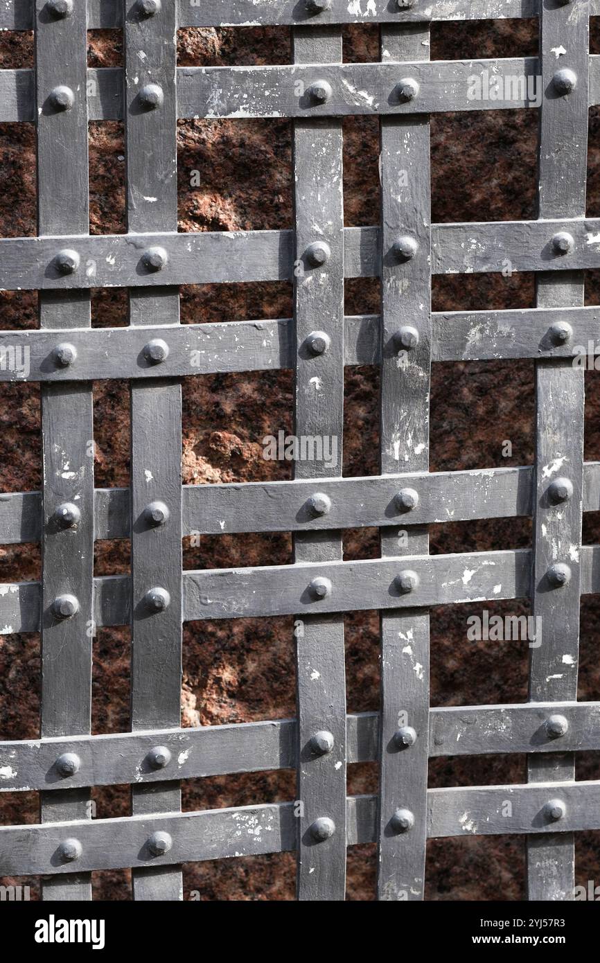 Strong metal fence by a rock Stock Photo - Alamy