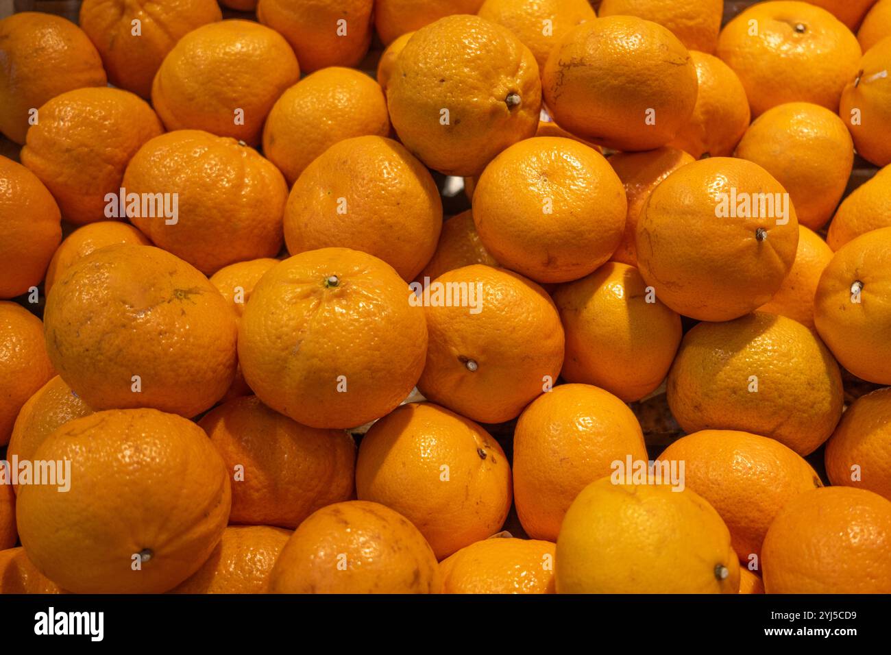 A pile of bright, fresh oranges stacked together, displaying vibrant ...