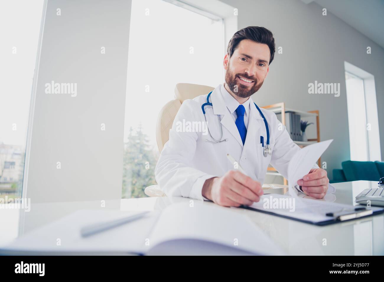 Photo of experienced doctor guy smiling writing checklist medical ...