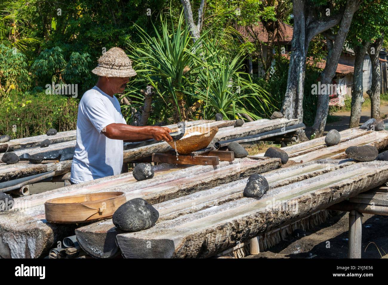 Man gathering sea water to produce sea salt in Amuk Bay, Eastern Bali ...